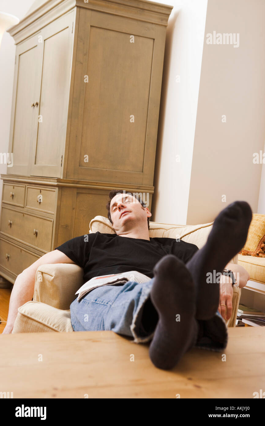 Man sleeping in chair with feet up Stock Photo - Alamy