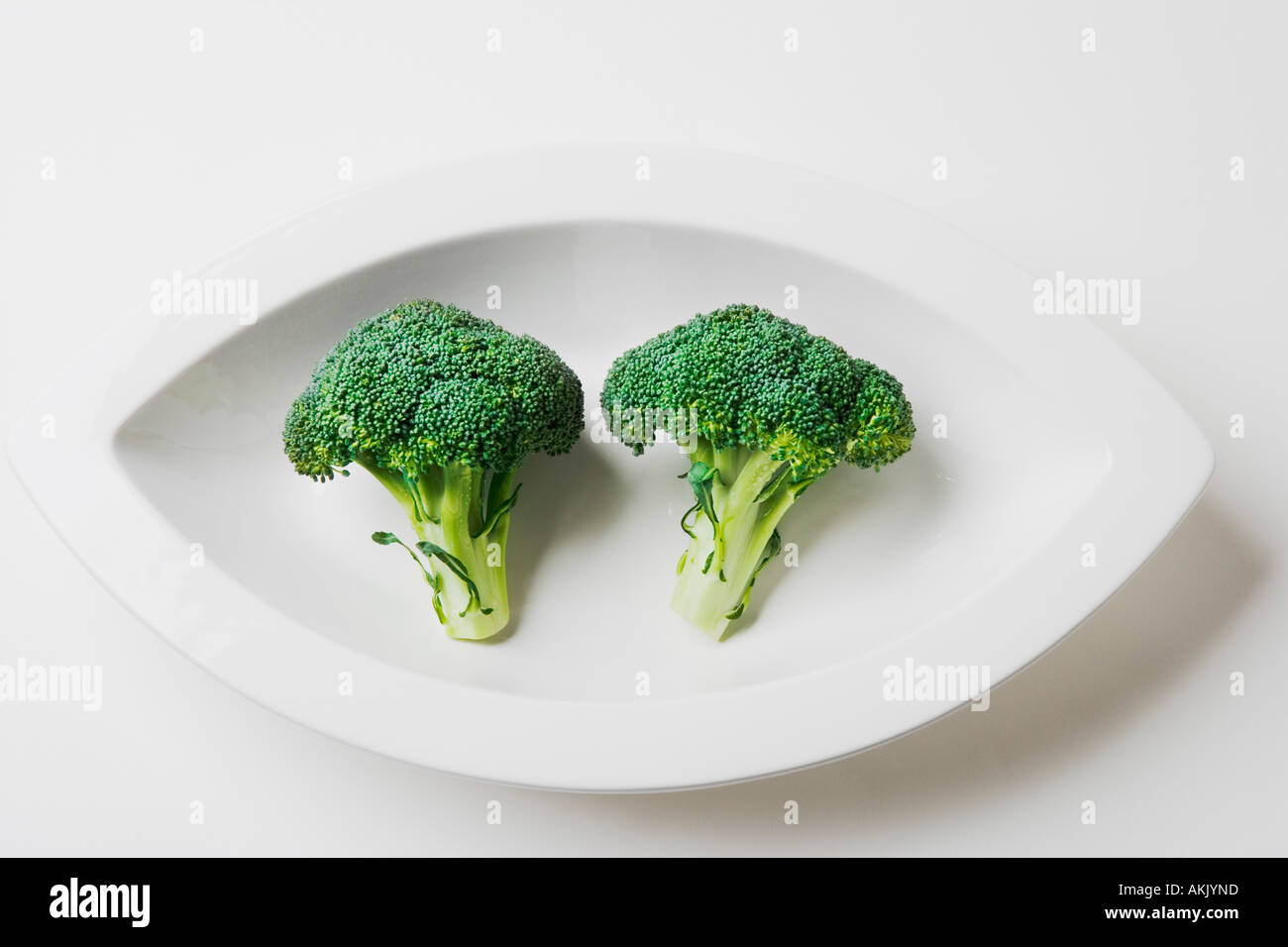 Two broccoli crowns in a dish Stock Photo - Alamy
