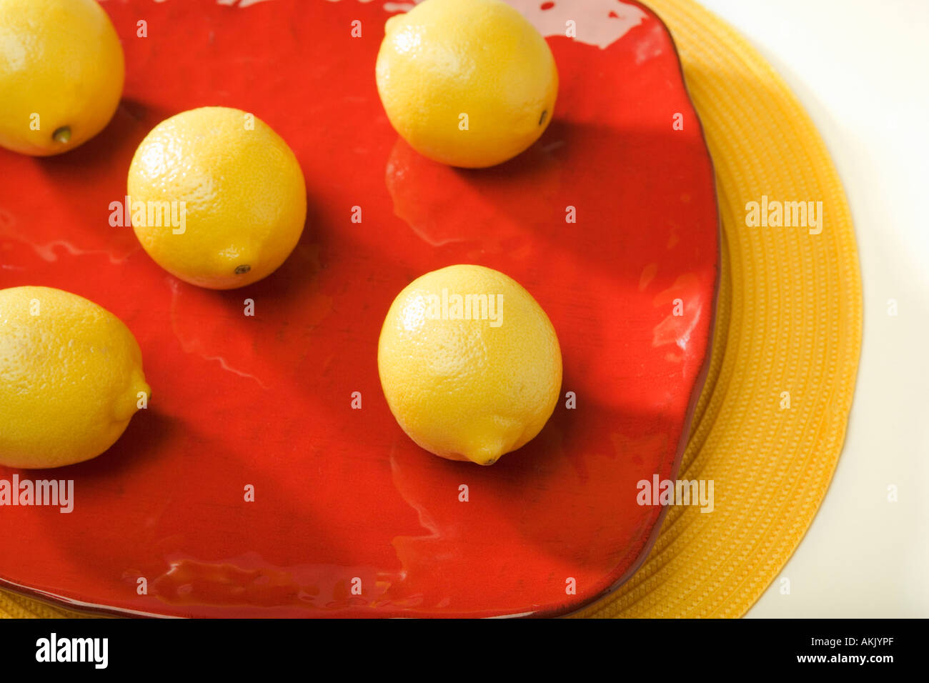 Lemons on red platter Stock Photo - Alamy