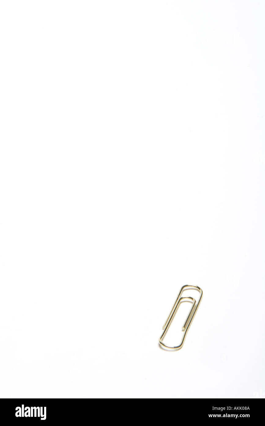 A single Gold coloured paperclip on white background Stock Photo - Alamy