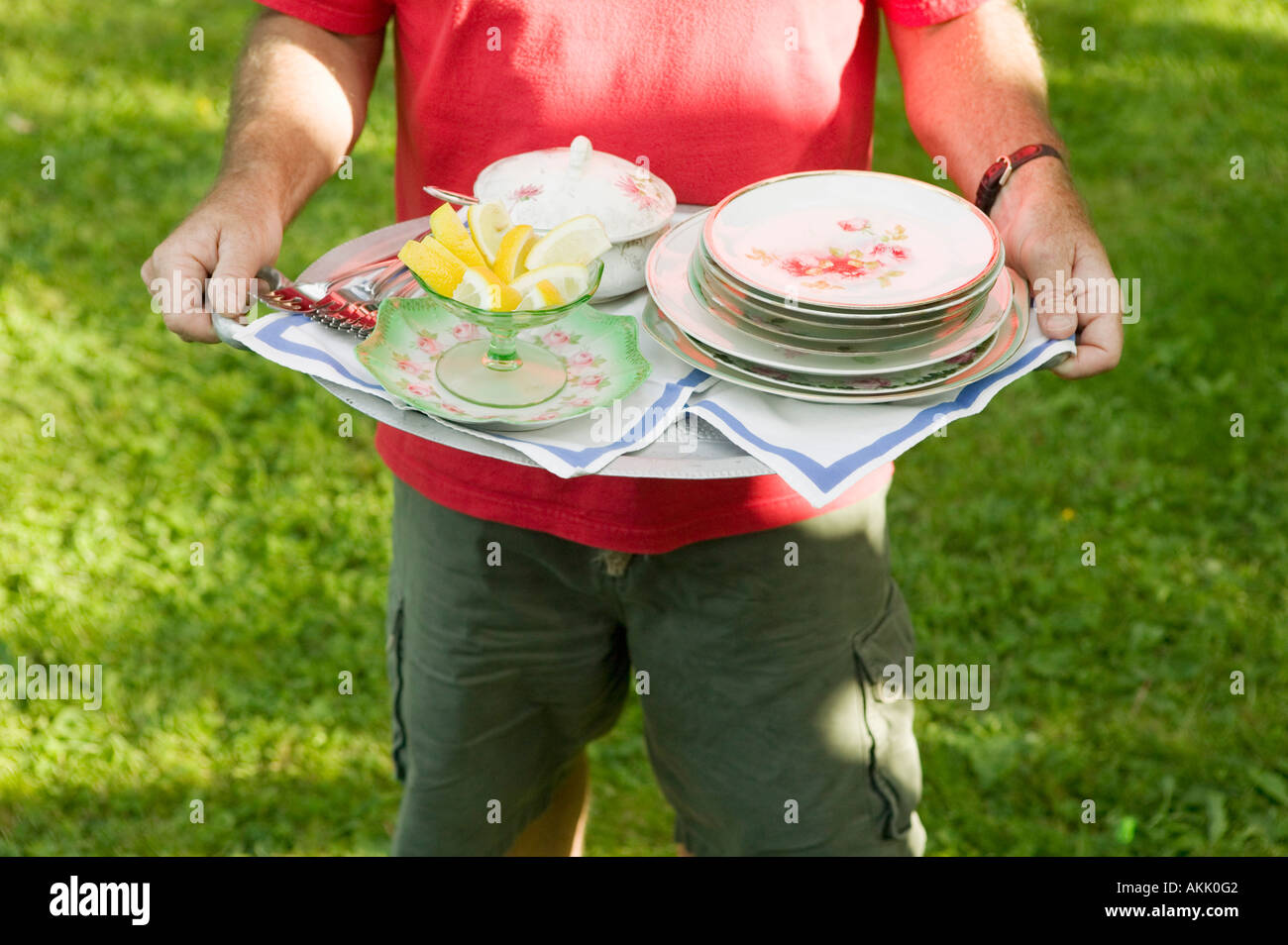Man carrying tray of dishes outside Stock Photo - Alamy