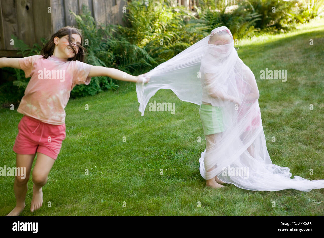 Young girl wrapping friends in fabric Stock Photo - Alamy
