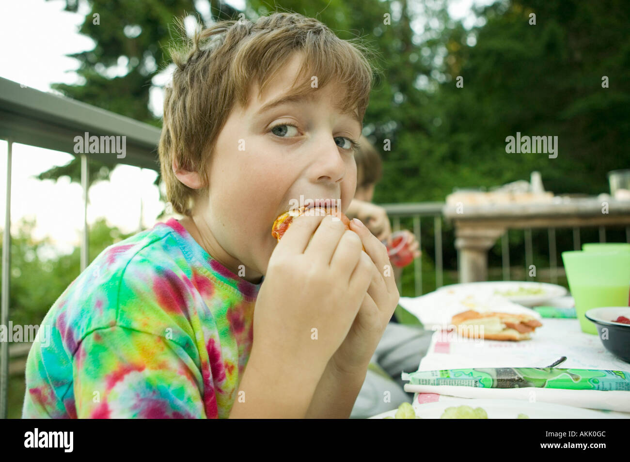 Young boy eating lunch outside Stock Photo - Alamy