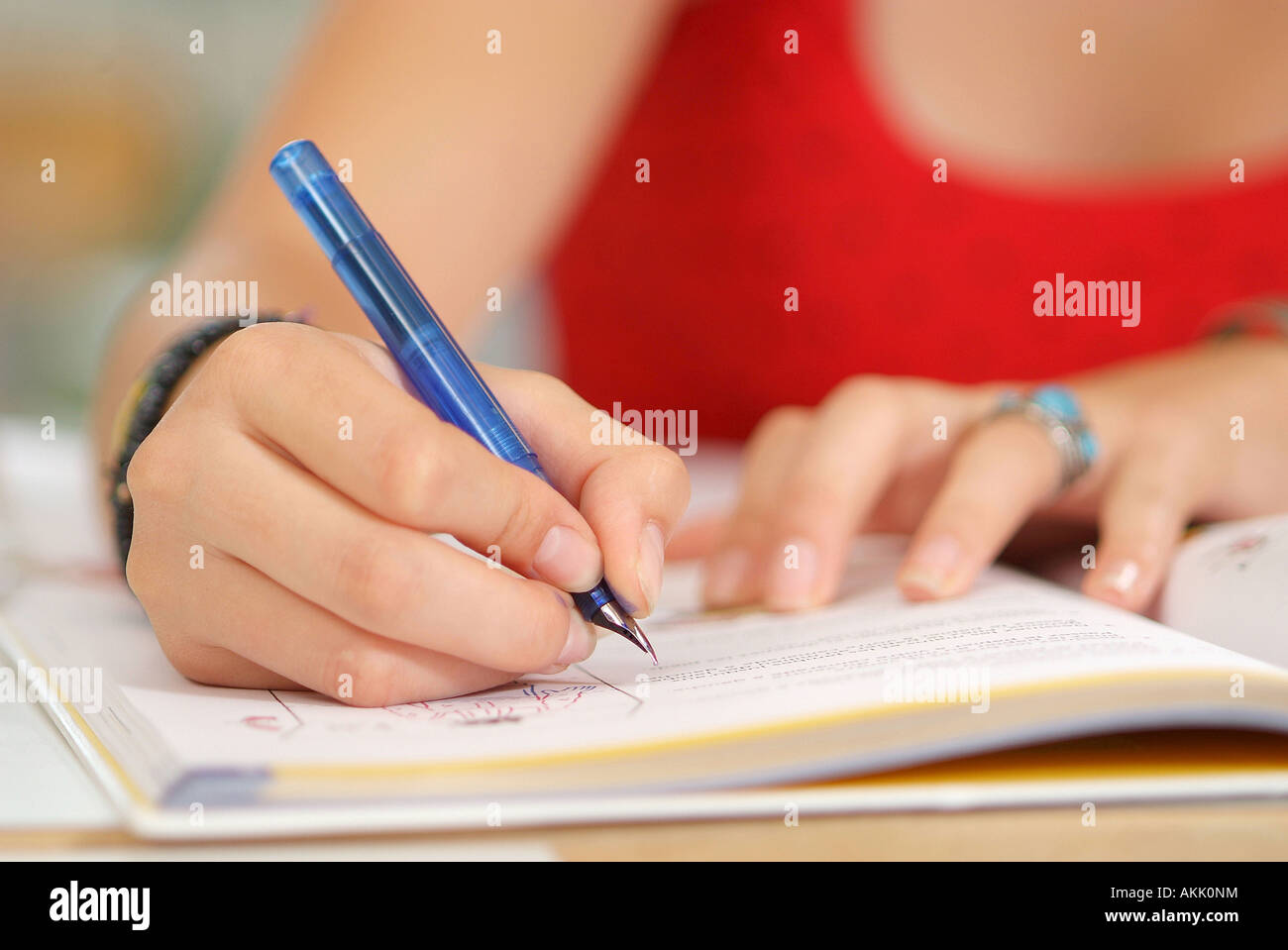 girl writing in a text book Stock Photo - Alamy