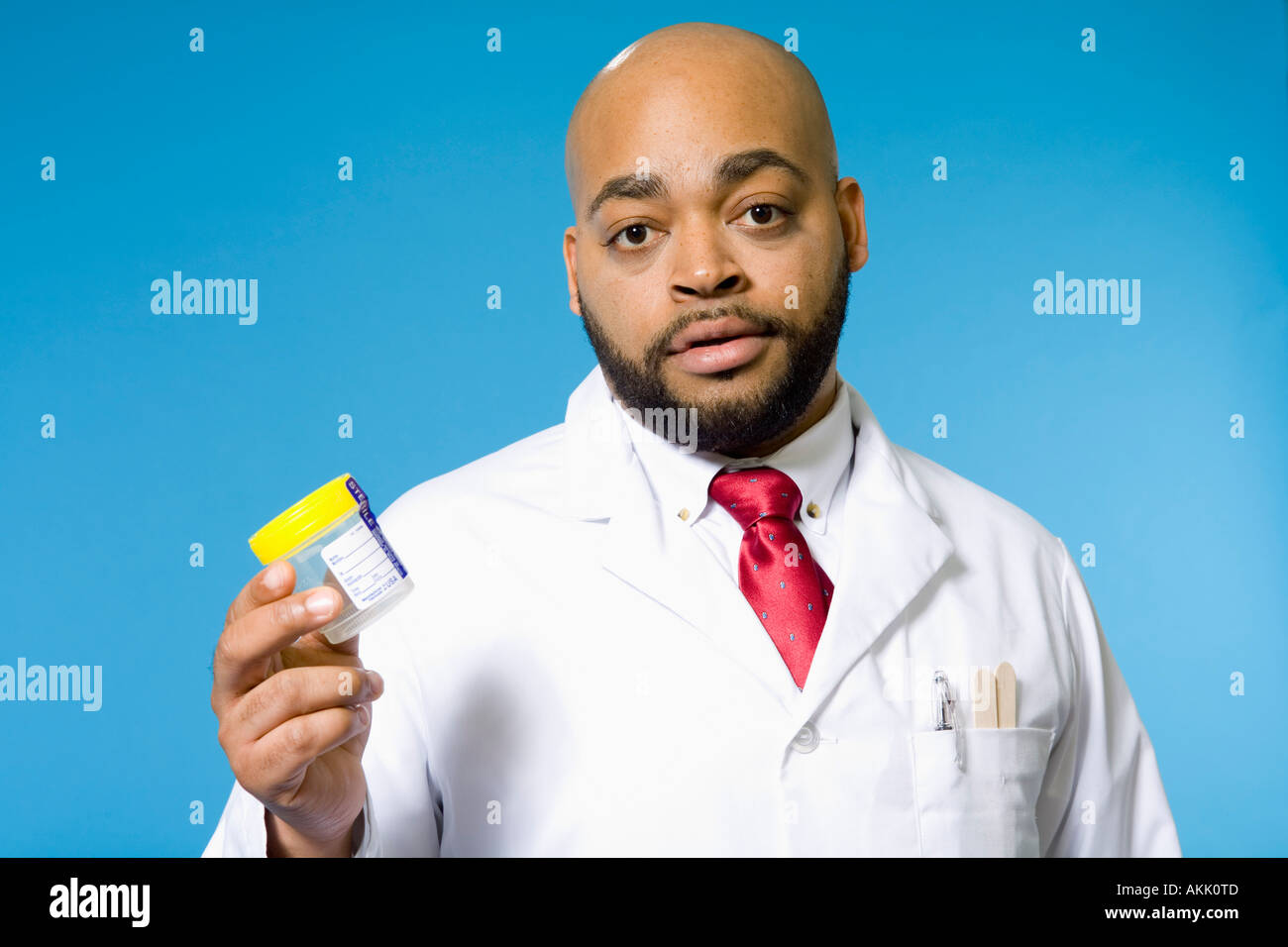 Portrait of male doctor holding container Stock Photo - Alamy