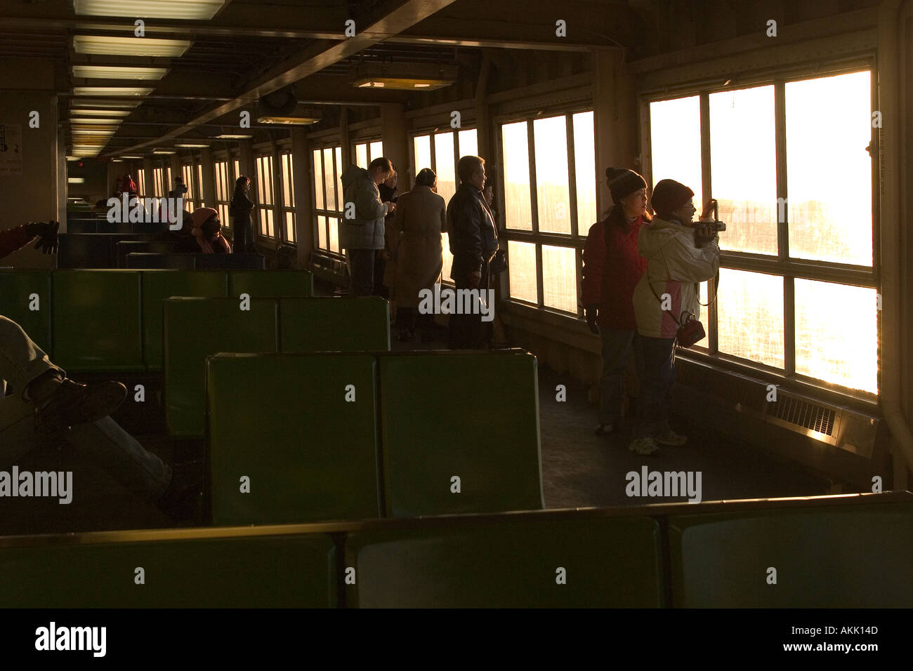 Passengers on the Staten Island Ferry look look out at New York Harbor ...