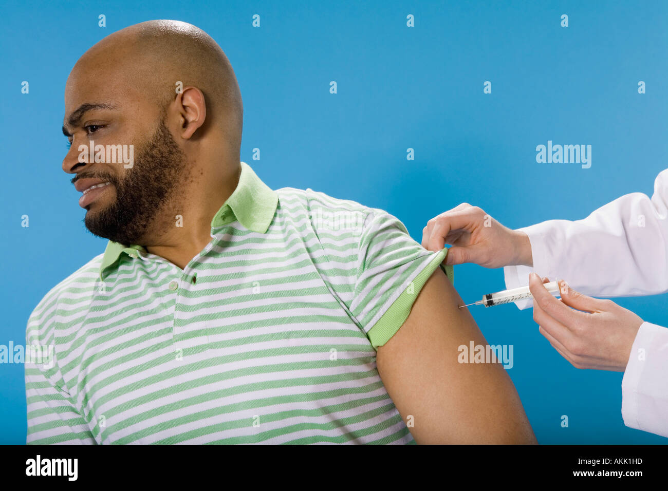 Man receiving injection in arm Stock Photo - Alamy