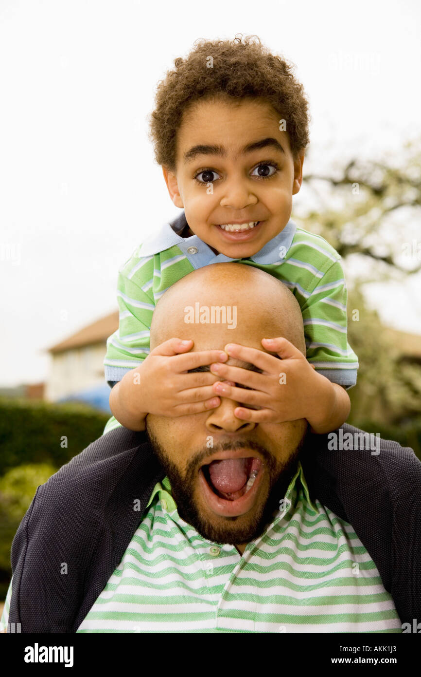 Portrait of boy covering father’s eyes Stock Photo - Alamy