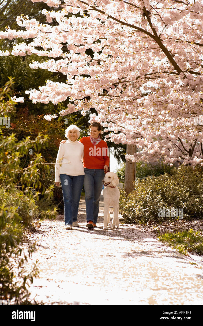 Two women walking dog Stock Photo - Alamy