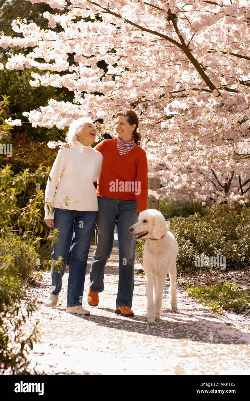 Two women walking dog Stock Photo - Alamy