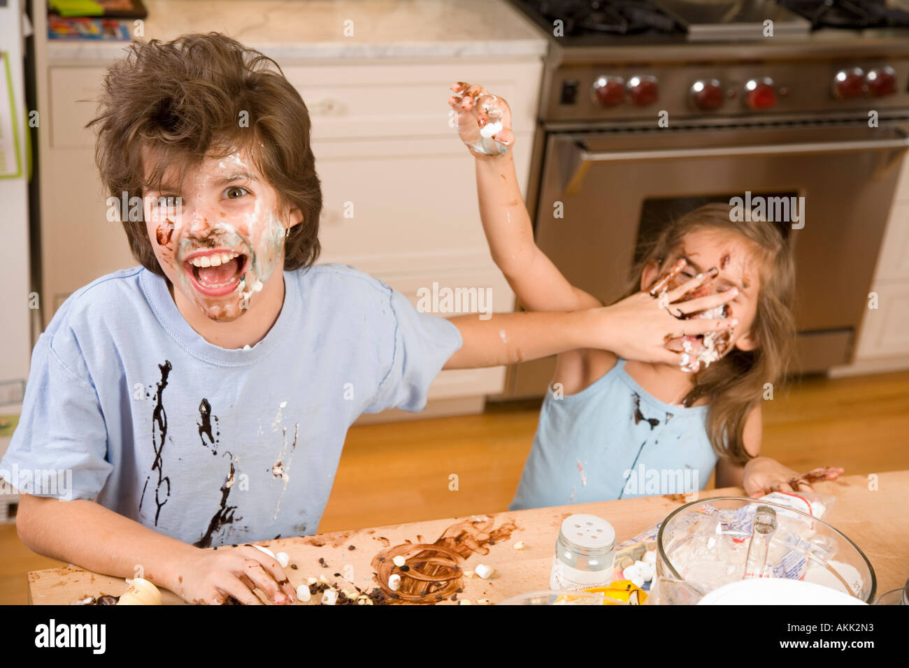 Boy smearing food on sister’s face Stock Photo - Alamy
