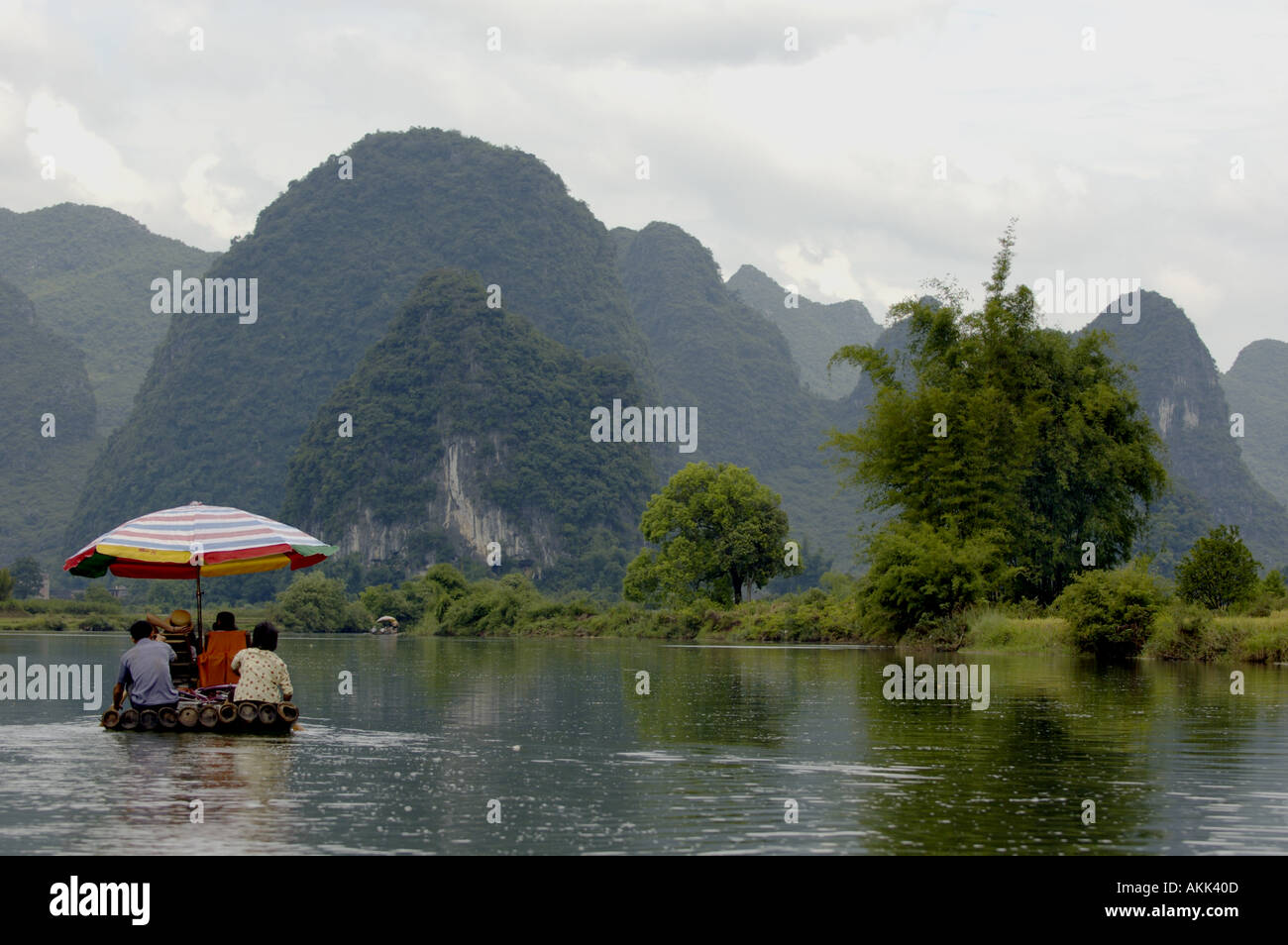 Chinese couple rowing a bamboo raft along the Yulong River with a ...