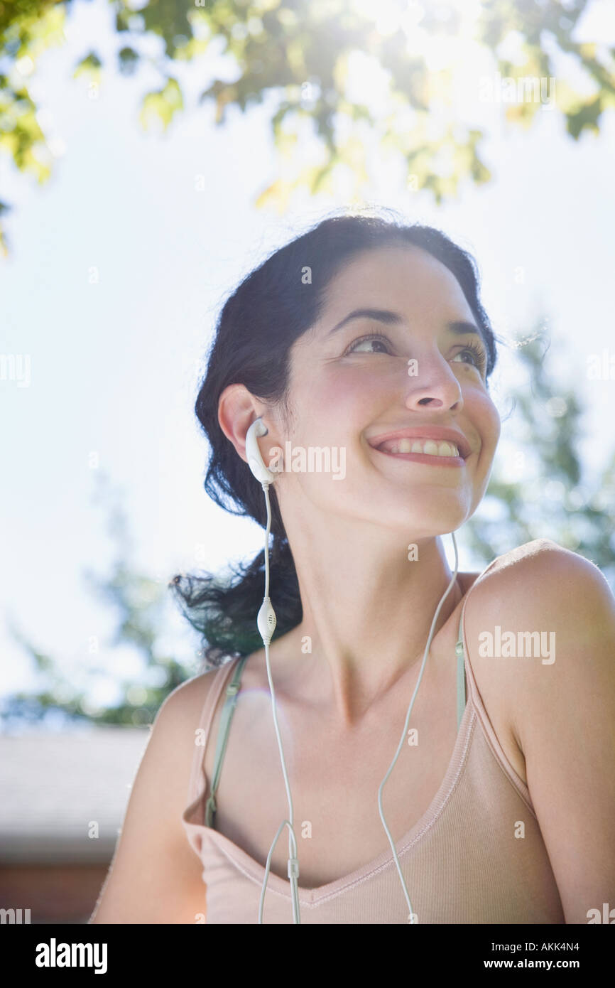Young woman listening to earbuds Stock Photo - Alamy