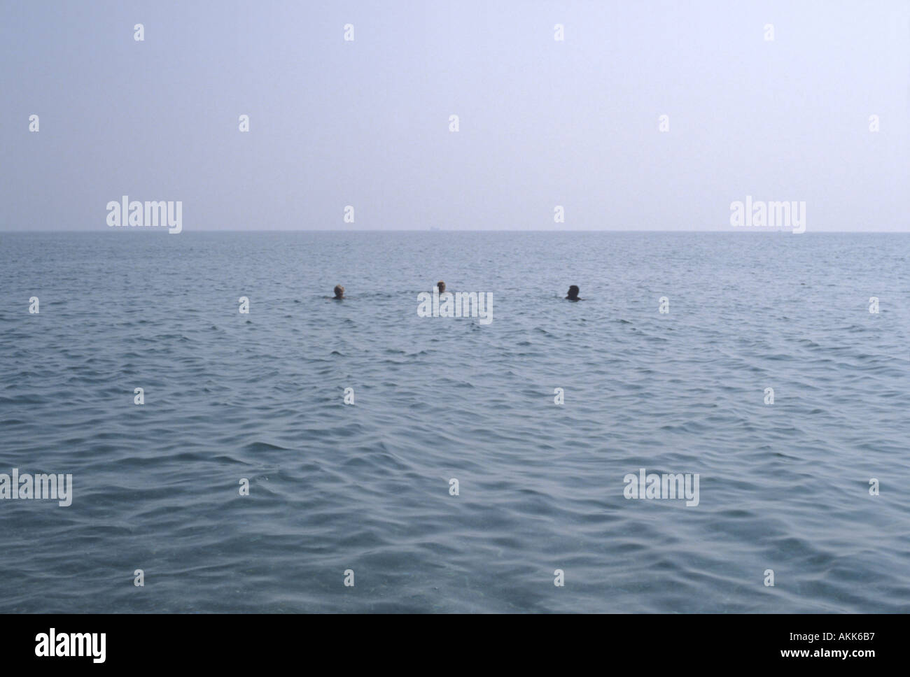 three people swimming far out in the ocean Stock Photo - Alamy