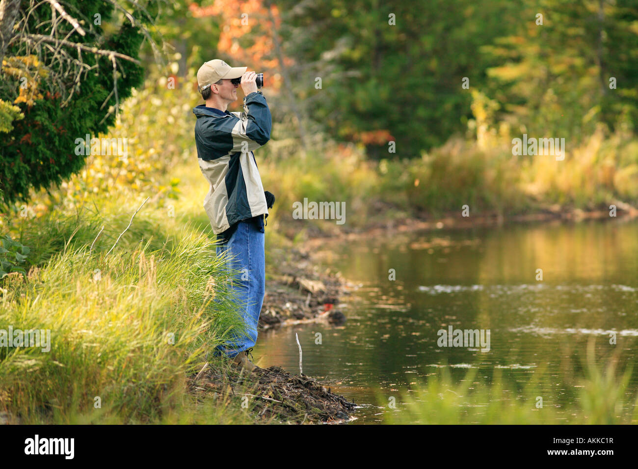 Man using binoculars while birding McMahon Lake Forest Preserve ...