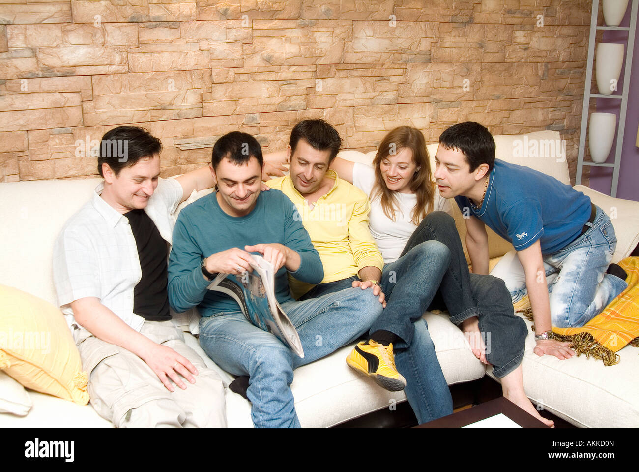 Group of friends reading the newspaper together on a sofa Stock Photo ...