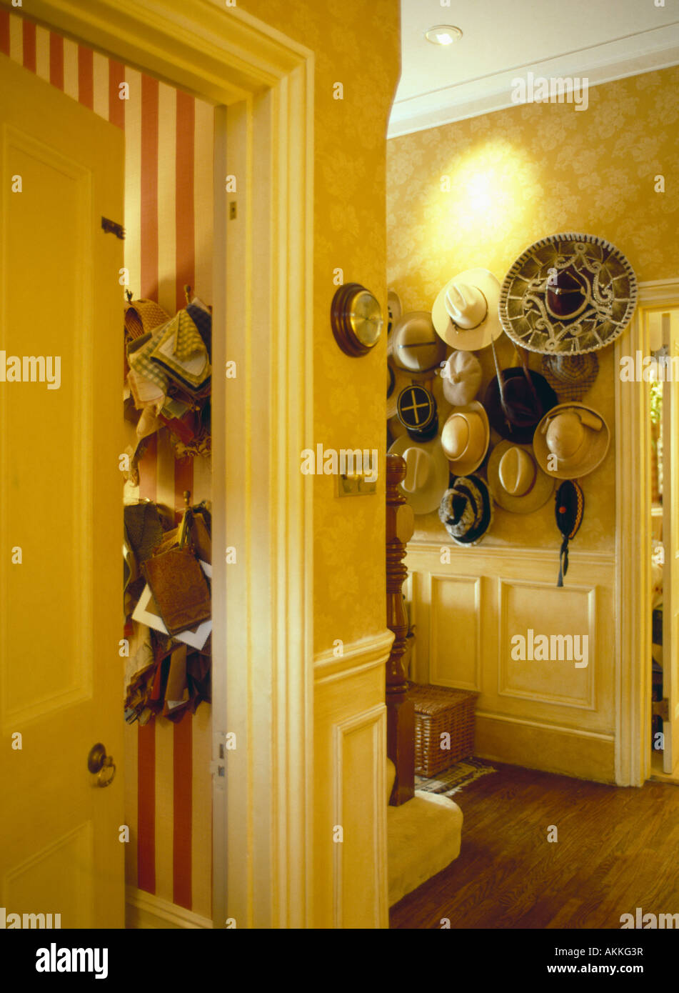 Patterned wallpaper in yellow hall with hat collection on hatstand on ...