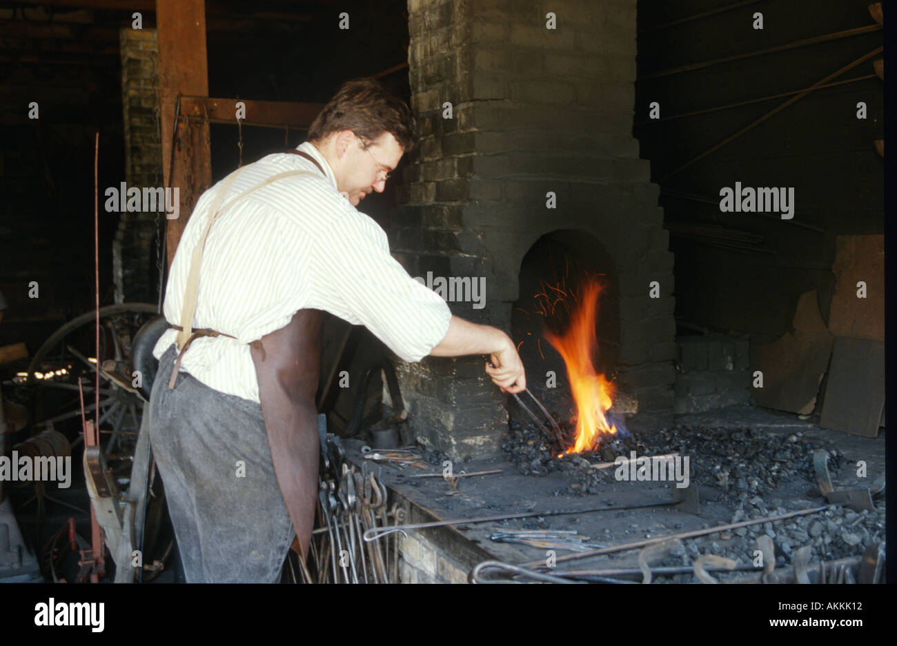 WISCONSIN Old World Wisconsin Blacksmith with apron place metal into ...