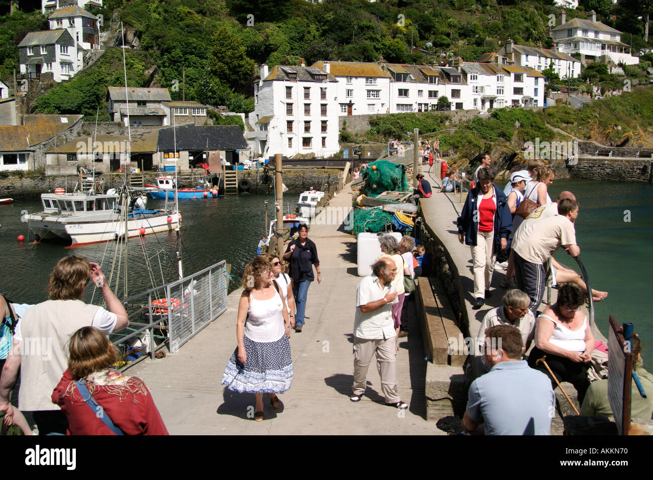 Tourist on harbour wall Polperro Harbour Cornwall England Summer 2005 ...