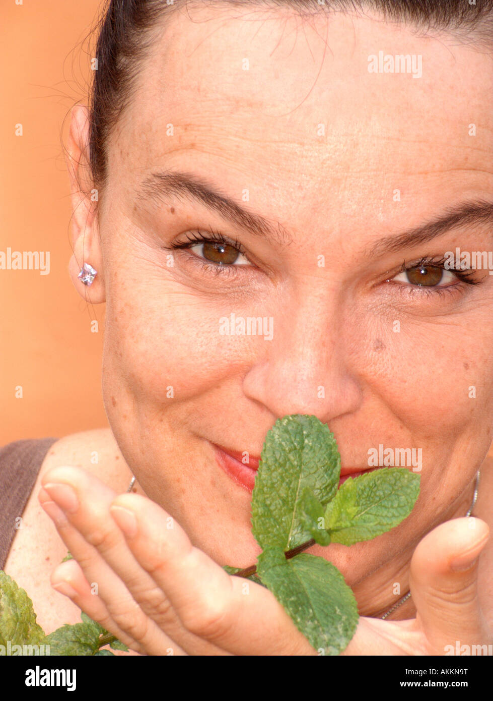 Woman smelling a branch of Mint (Mentha) plant Stock Photo - Alamy