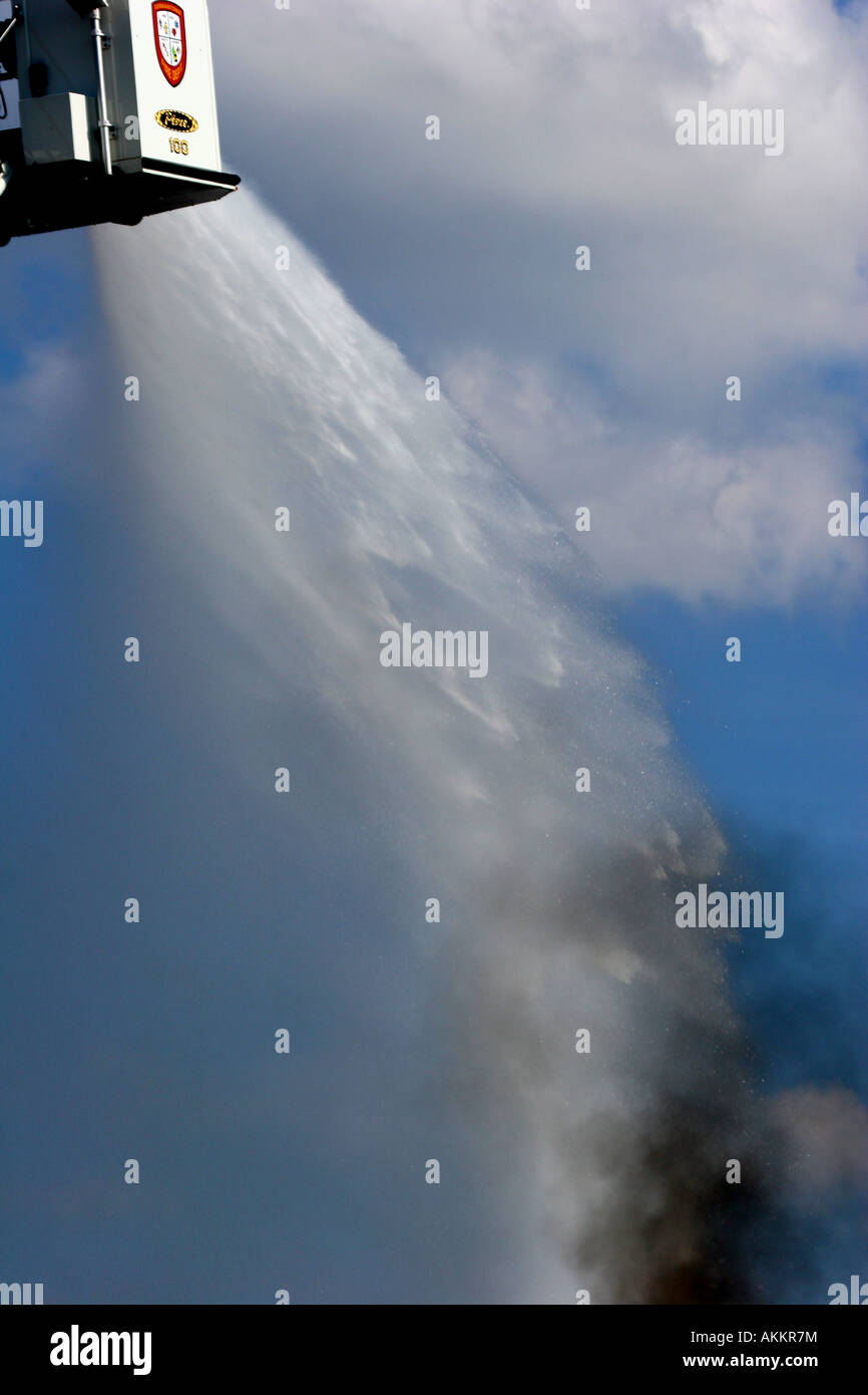 A firefighting platform spraying water on a fire were the black smoke ...