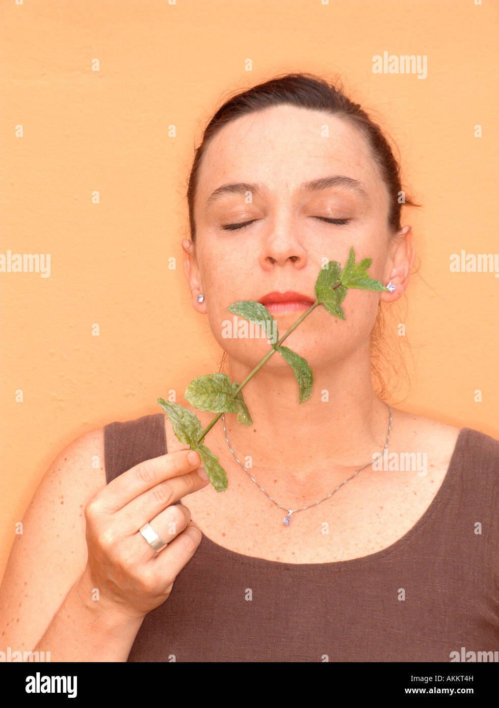 Woman smelling a branch of Mint (Mentha) plant Stock Photo - Alamy