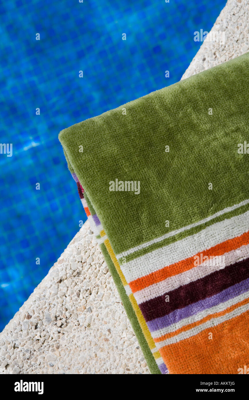 Folded beach towel by swimming pool Stock Photo - Alamy