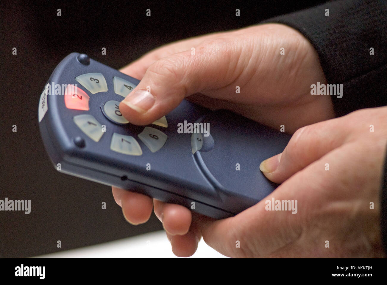 Woman using an electronic voting device at a meeting, London, UK Stock ...