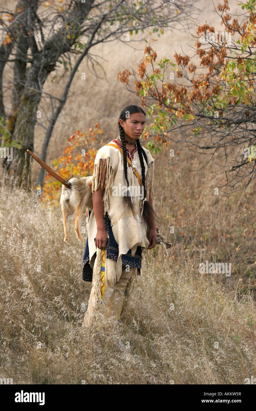 An Native American Indian walking through the grass during the fall who ...