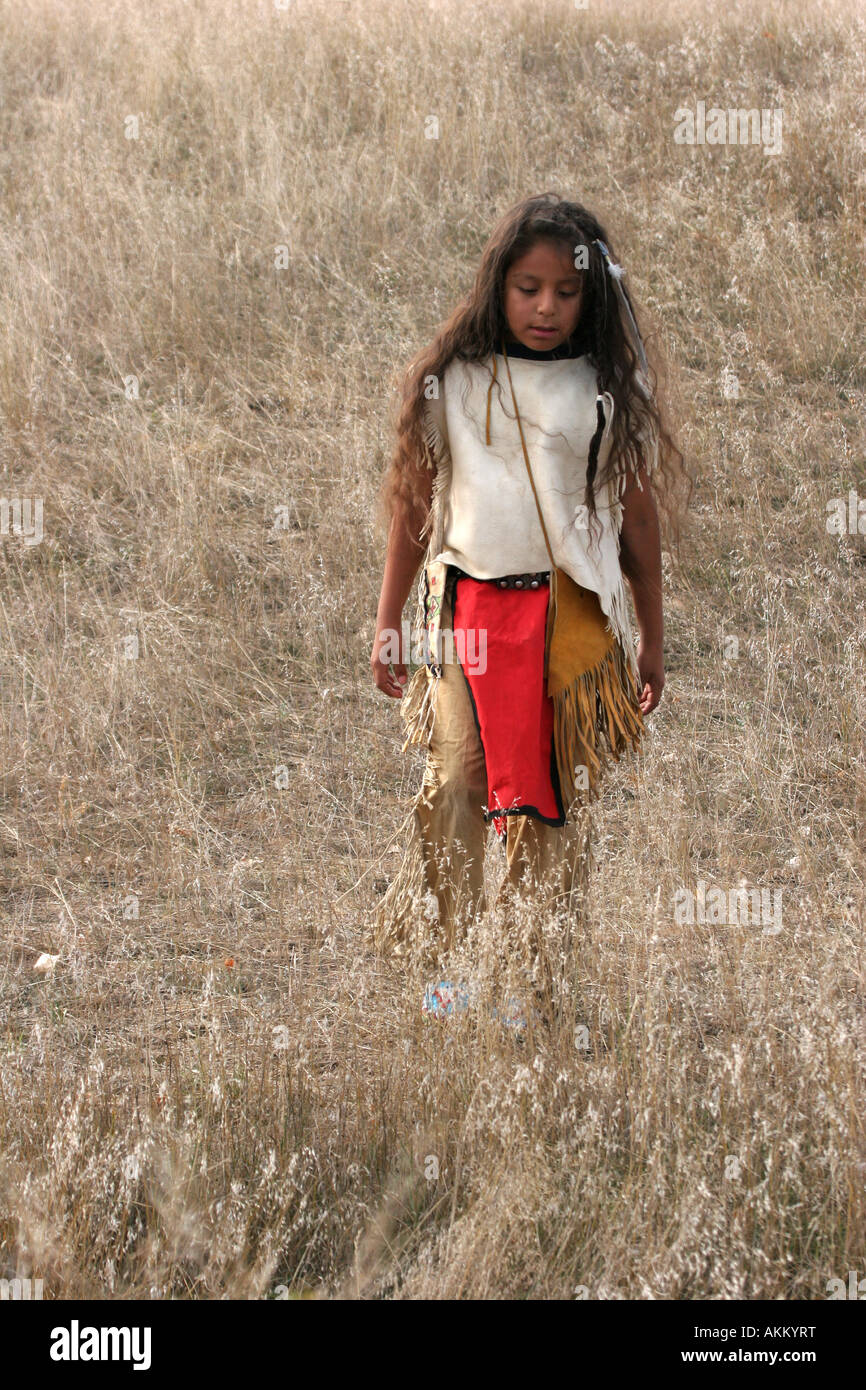 A young Native American Indian boy walking through the long dried grass ...