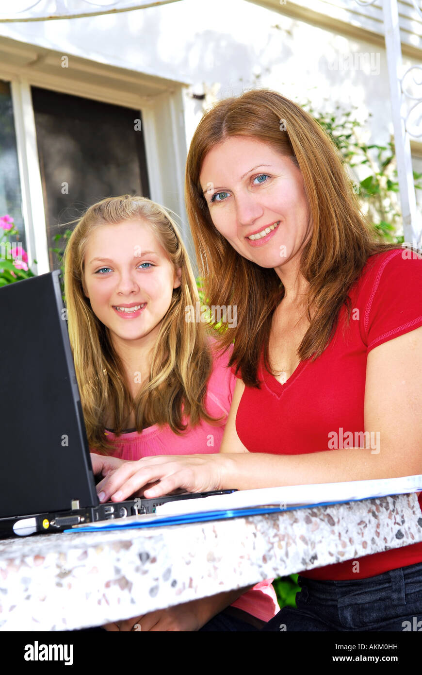 Mother and daughter working on a portable computer at home in the ...