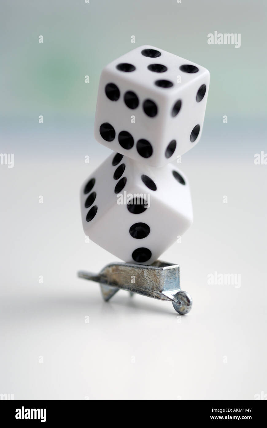 Monopoly wheelbarrow loaded with dice Stock Photo - Alamy