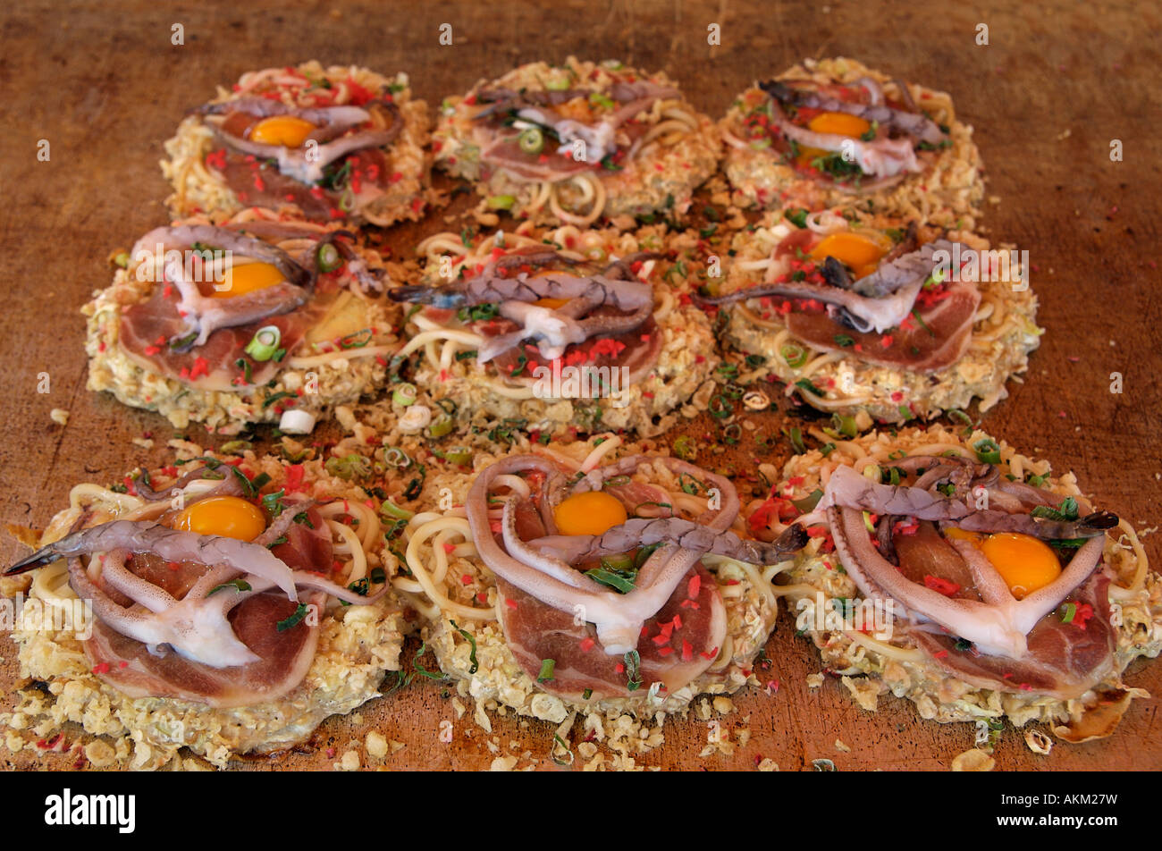 Okonomi yaki Japanese style savoury pancakes being cooked on a hot ...