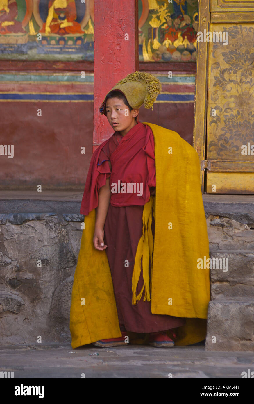 Novice monk in yellow robe and headwear at Tashilunpo monastery ...