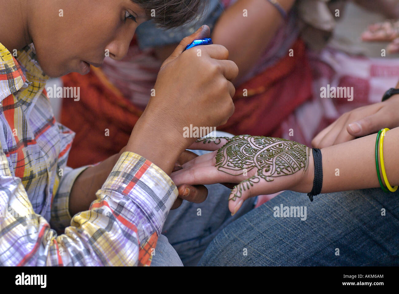 Young artisan henna painting a hand An Indian and Nepalese custom ...