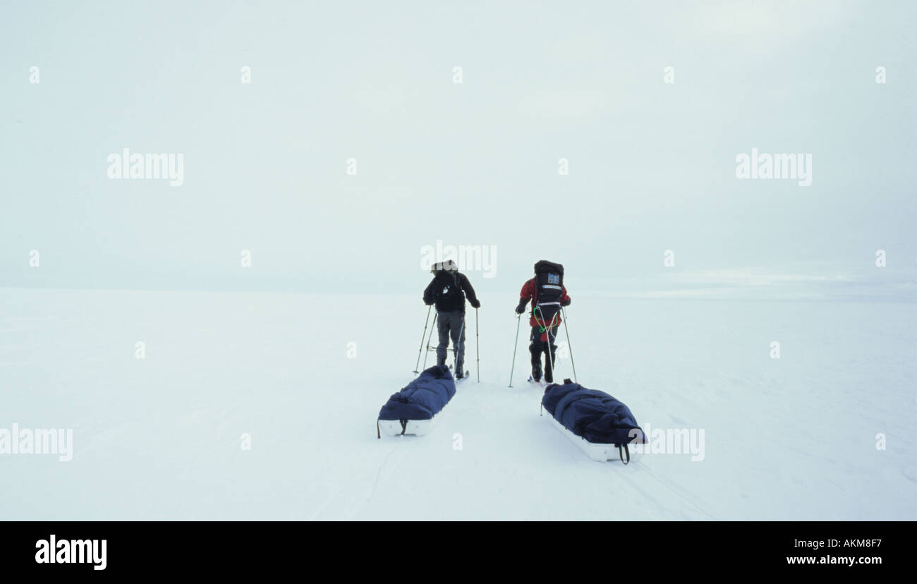 Two men pulling sledge on Greenland MODEL RELEASE Stock Photo - Alamy