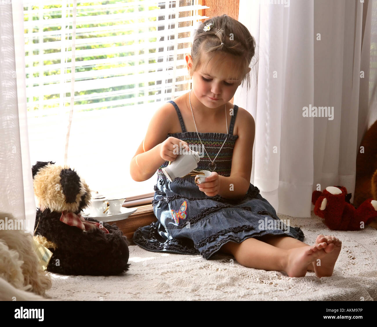 Girl sitting by window serving tea at McMaster Studio Stock Photo - Alamy