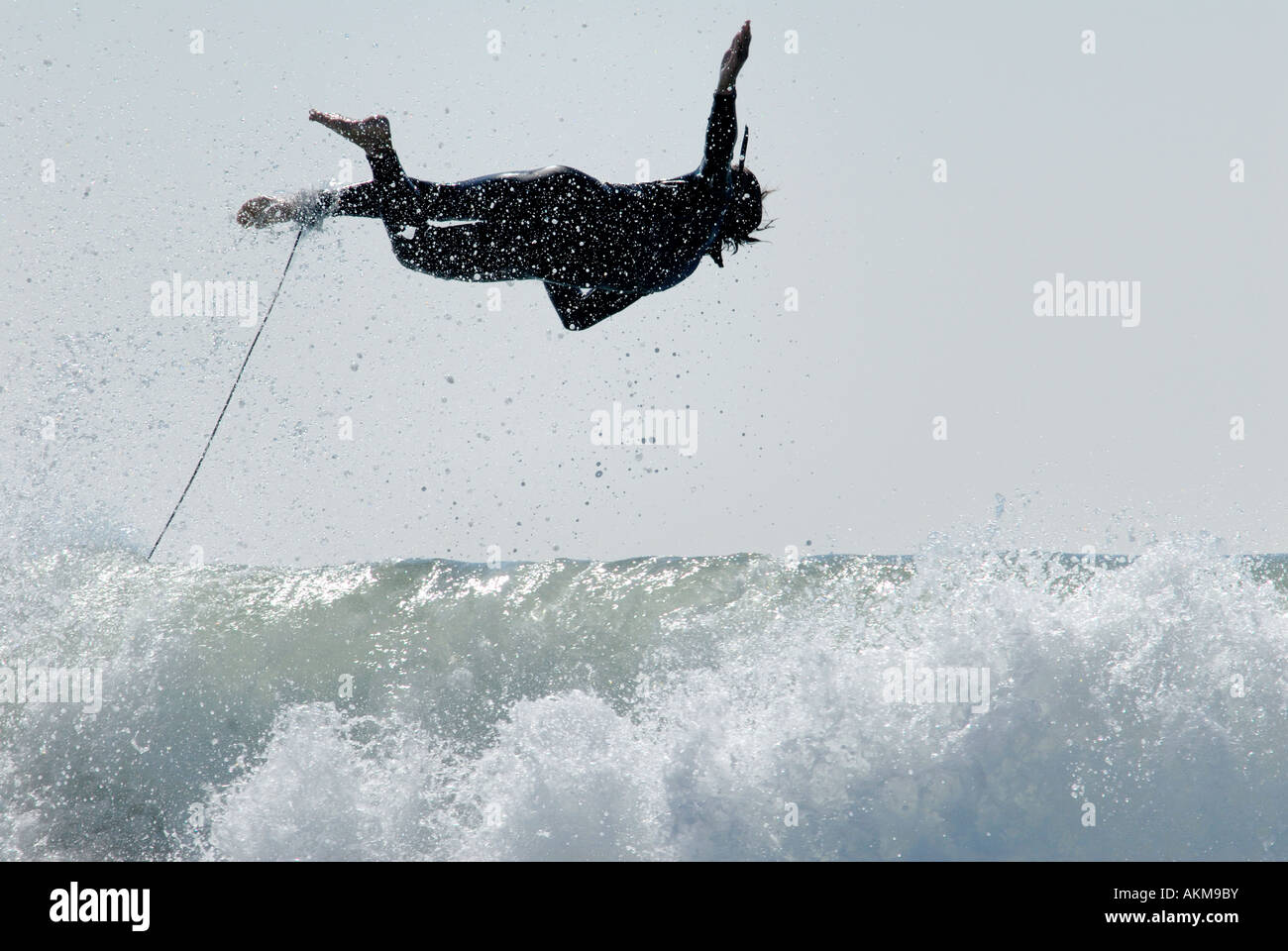 Surfer airborne over breaking wave Stock Photo - Alamy