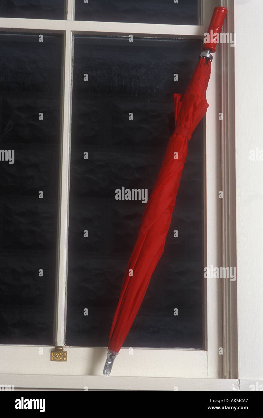 Red Umbrella Leaning Against Window Stock Photo - Alamy