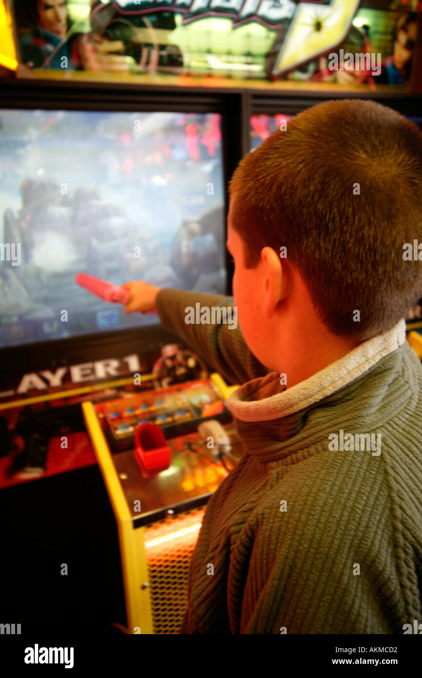 Boy Playing Shooting Game in Arcade Stock Photo - Alamy