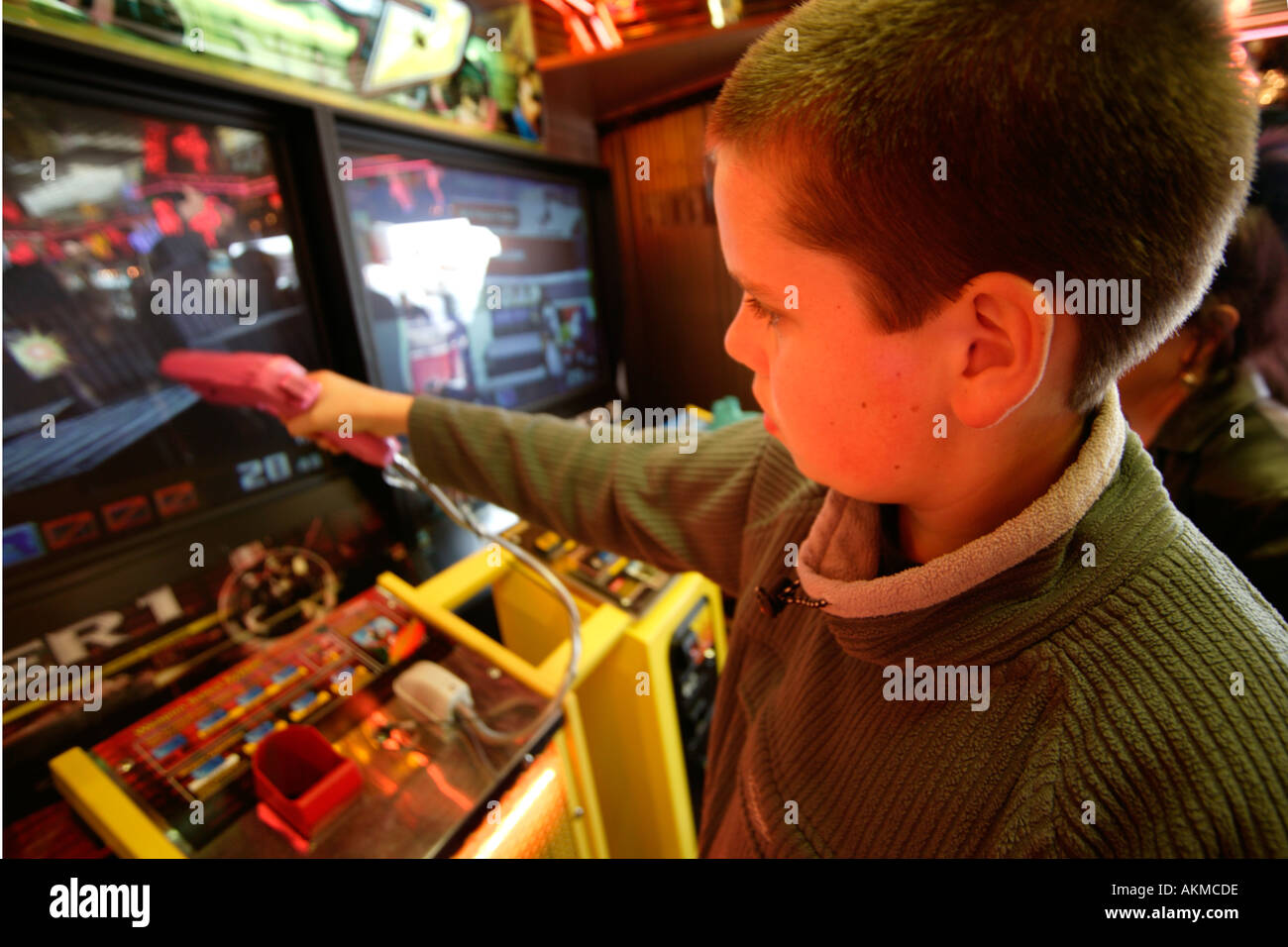 Boy Playing Shooting Game in Arcade Stock Photo - Alamy