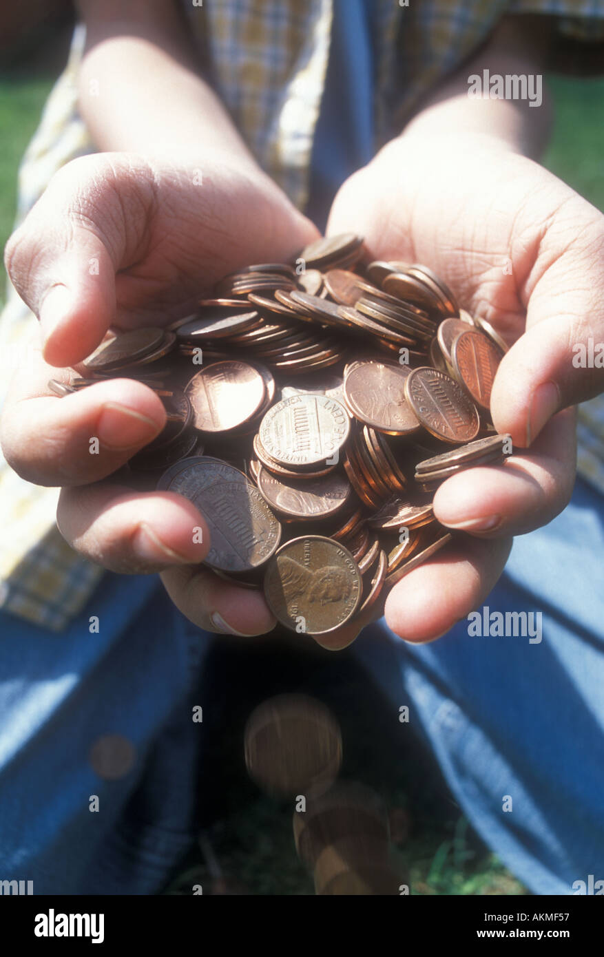 Pennies Falling from Young Boy's Hand Stock Photo - Alamy