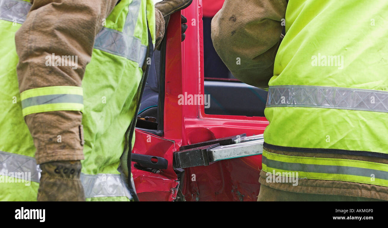 emergency services use a hydralic cutter to treat an injured driver in ...