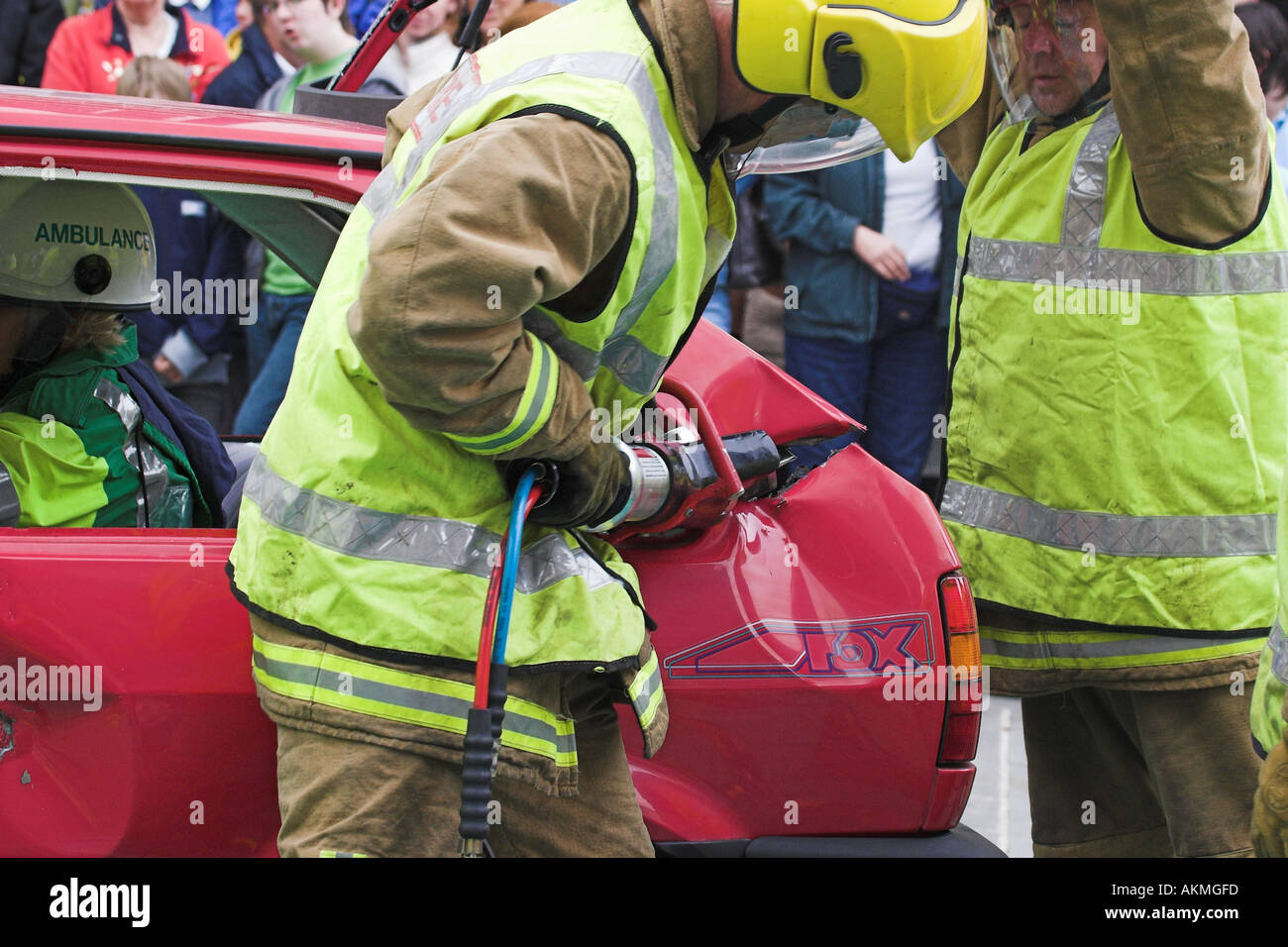 emergency services use a hydralic cutter to treat an injured driver in ...