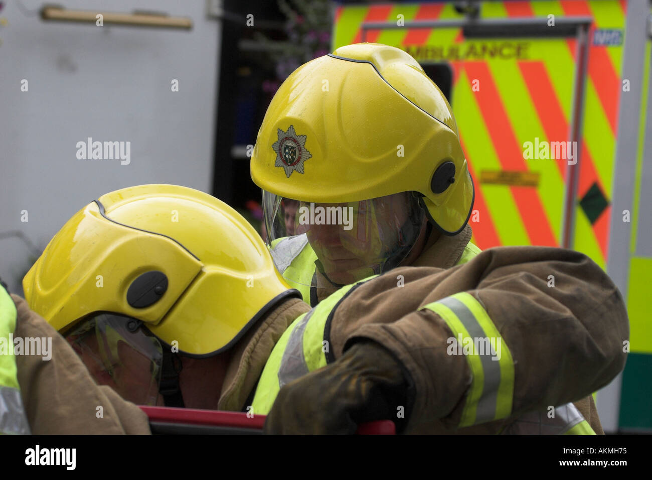 firemen at work at a road traffic accident with fire engine in the back ...