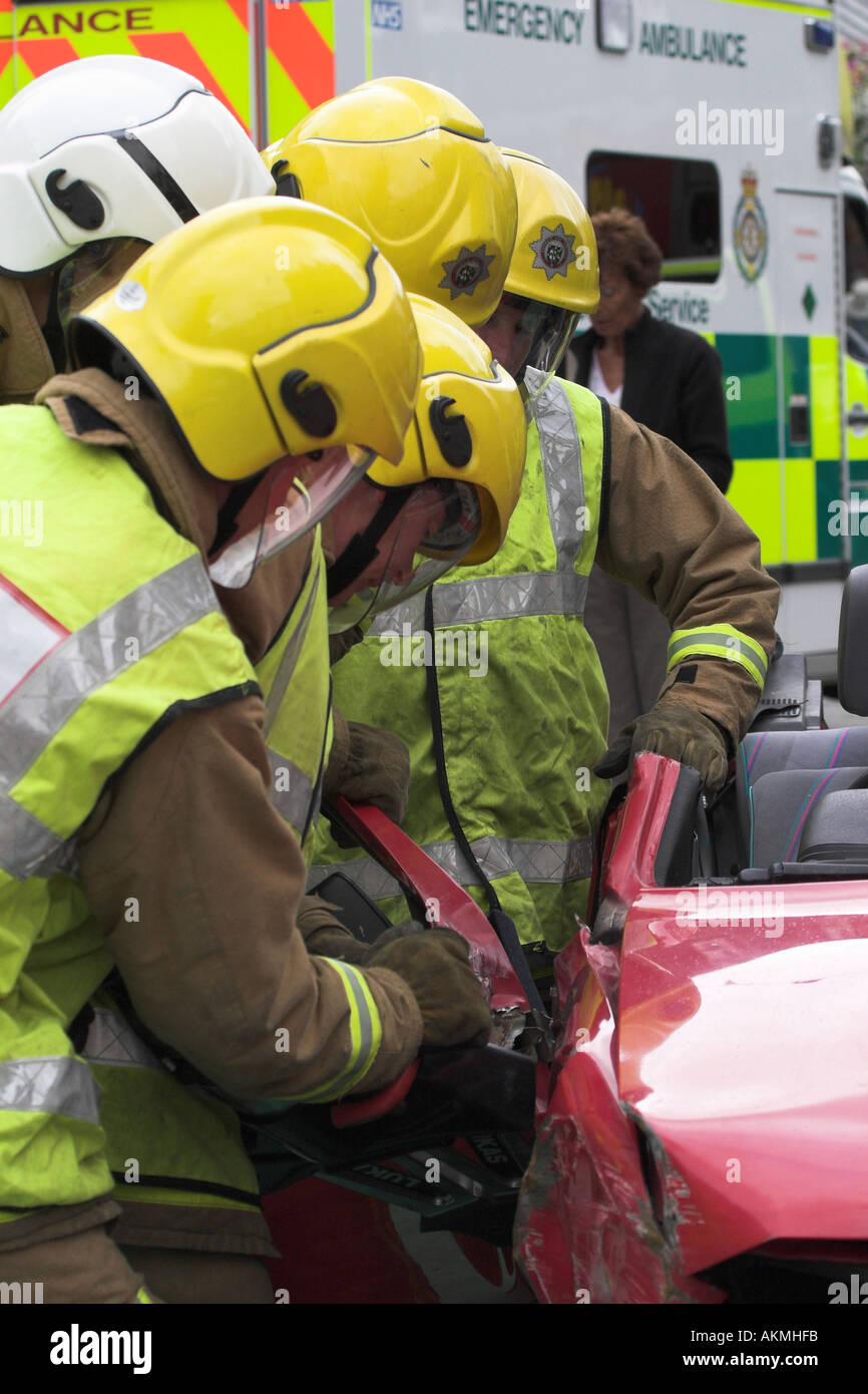 firemen treat an injured driver in a car crash Stock Photo - Alamy