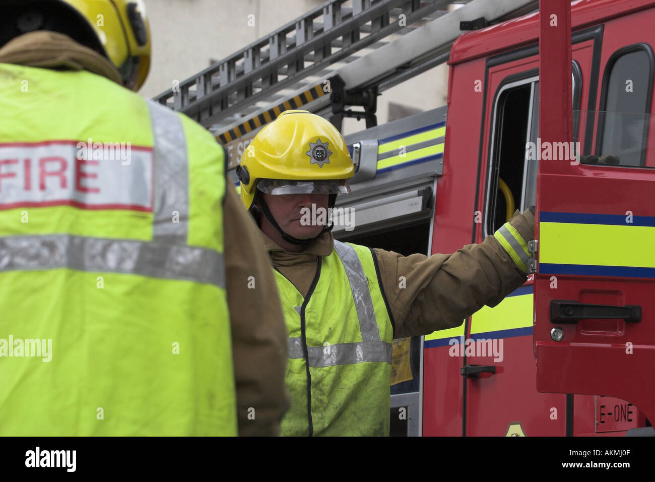 firemen talking in front of fire engine talking Stock Photo - Alamy