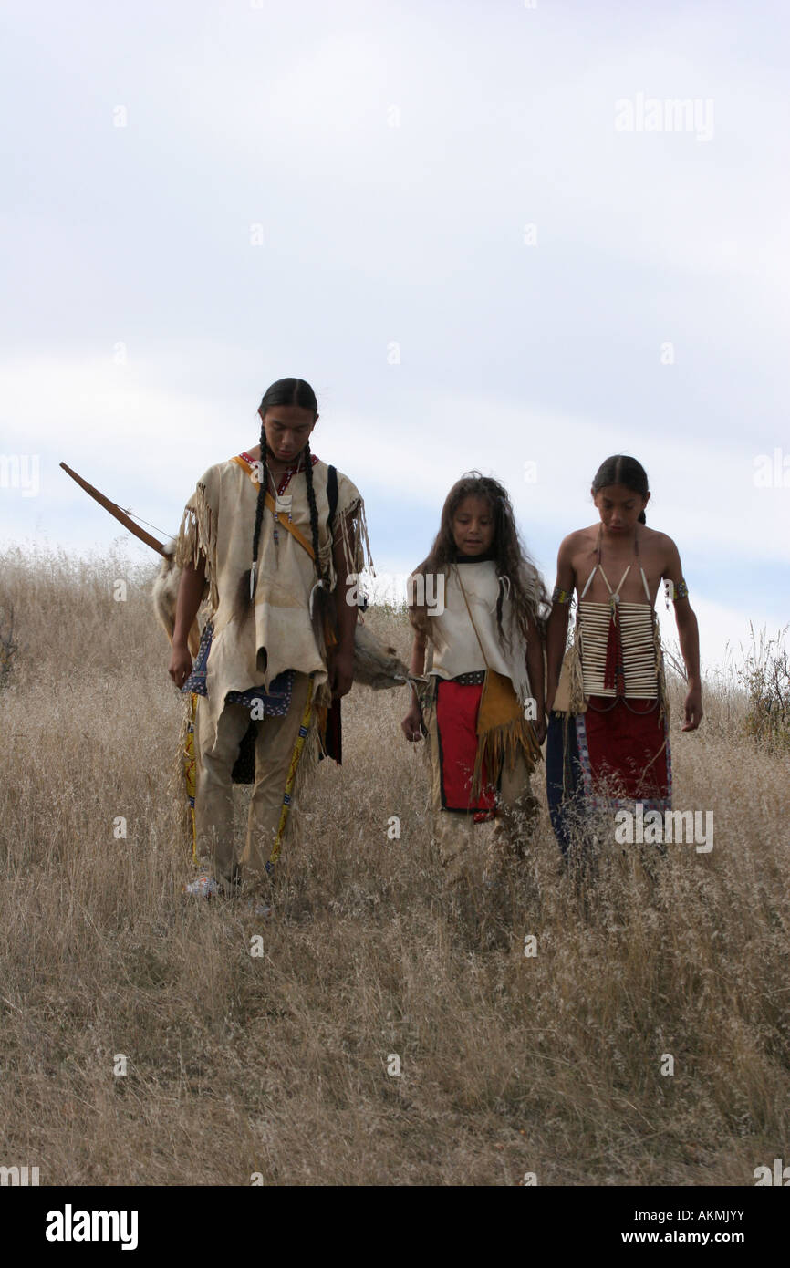 Three young Native American Indian boys walking through the dry grass ...