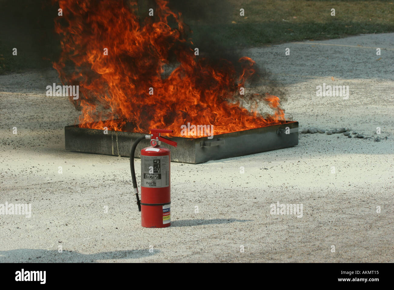 Fire Extinguisher displayed in front of a fire lit in a demonstration ...