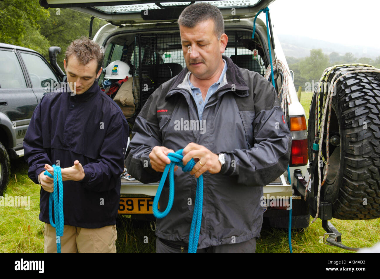 Instructor showing students how climb a tree on a tree climbing course ...